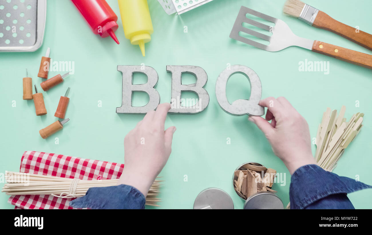 Metal BBQ sign with grilling tools on blue background Stock Photo - Alamy