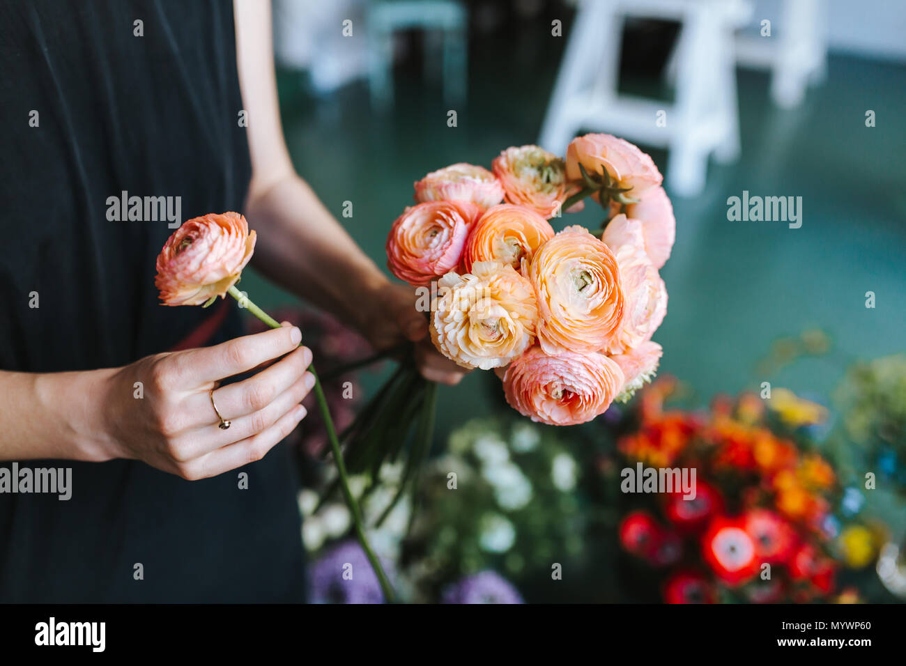 hands of florist arranging a bouquet of beautiful colorful flowers ...