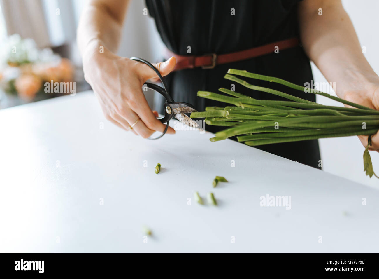 florist cutting the green stalks of a bouquet of flowers Stock Photo ...