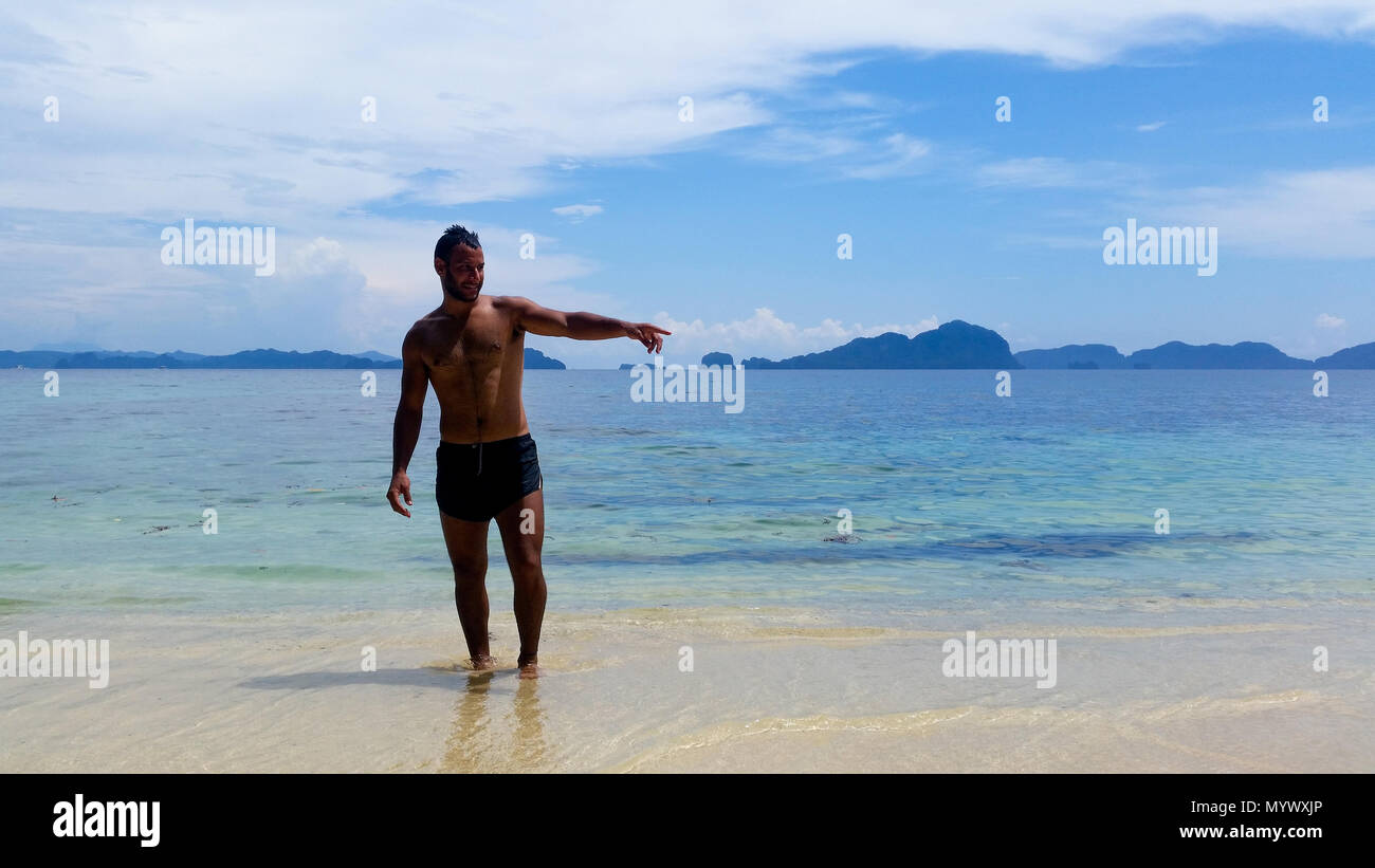 man pointing while standing in a tropical island. Palawan, Philippines ...