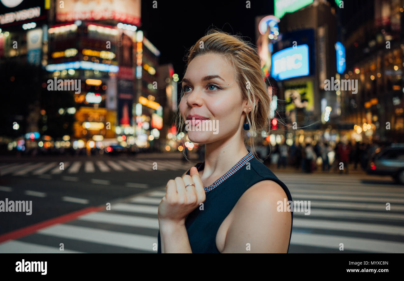 Woman exploring Shibuya Station famous crosswalk at night Stock Photo ...