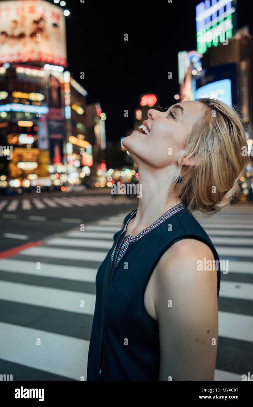 Woman exploring Shibuya Station famous crosswalk at night Stock Photo ...