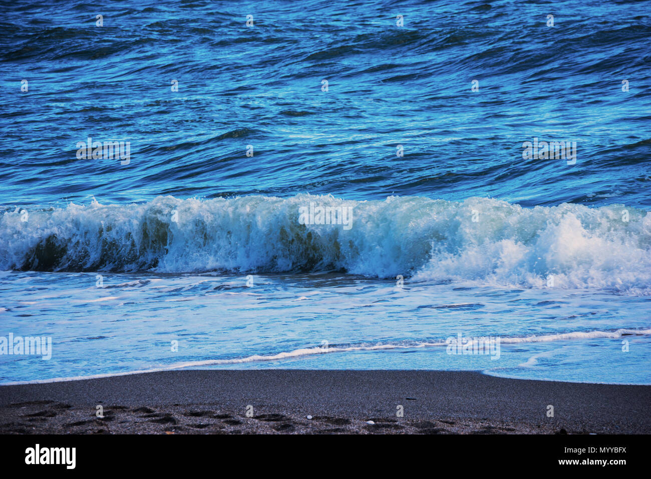 close up of the sea water affecting the sand on the beach, sea waves ...