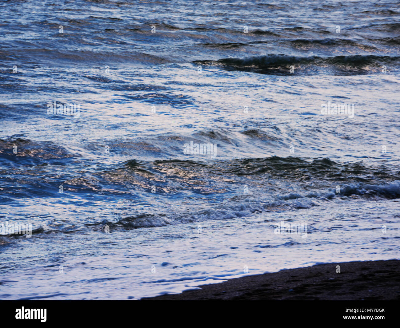 close up of the sea water affecting the sand on the beach, sea waves ...
