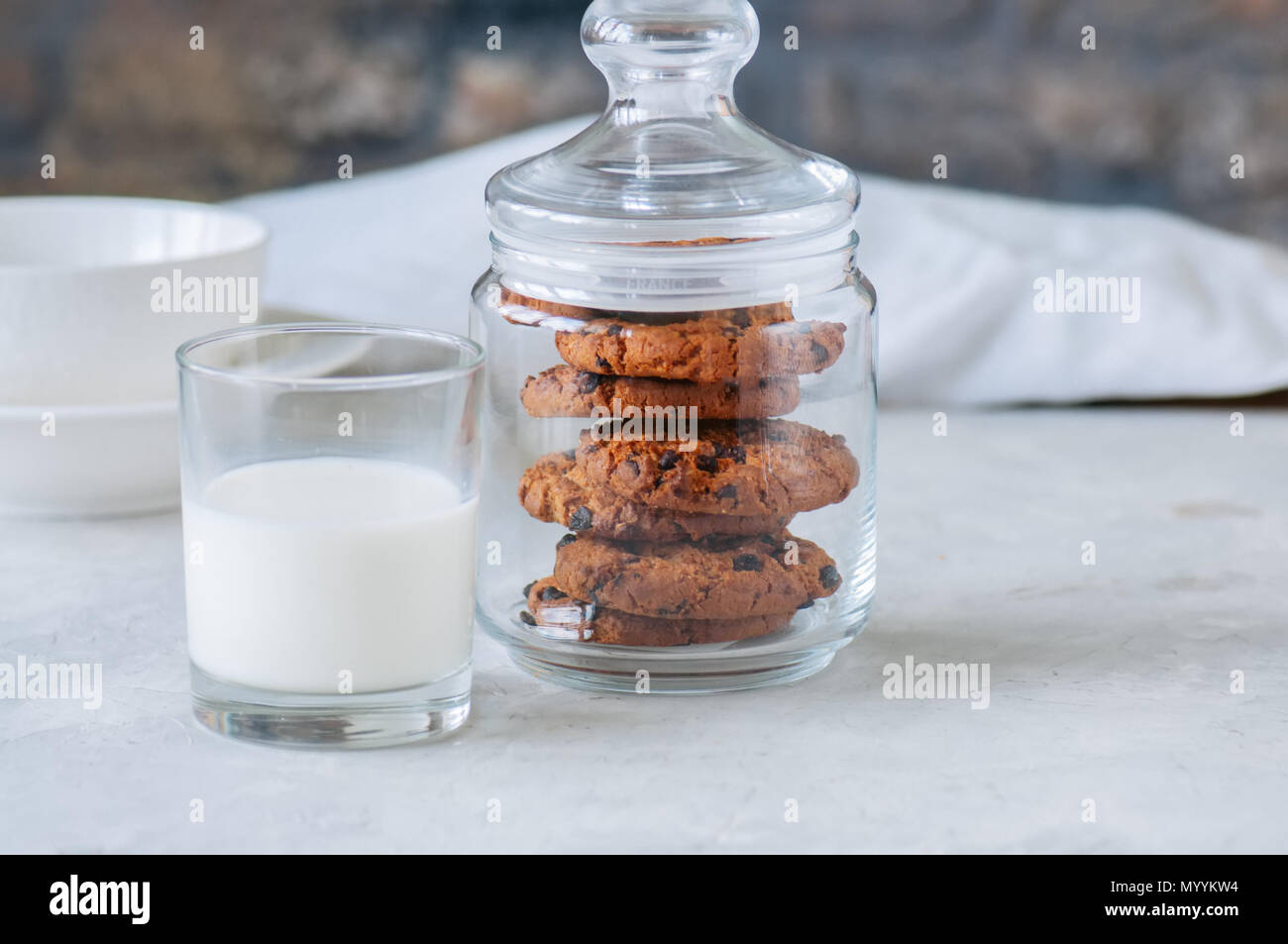Homemade chocolate chip cookies in a jar and glass of fresh milk on a ...