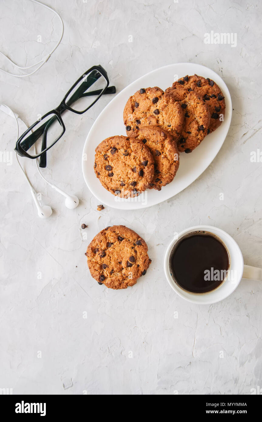 Chocolate chip cookies in a white plate cup of coffee eyeglasses and ...