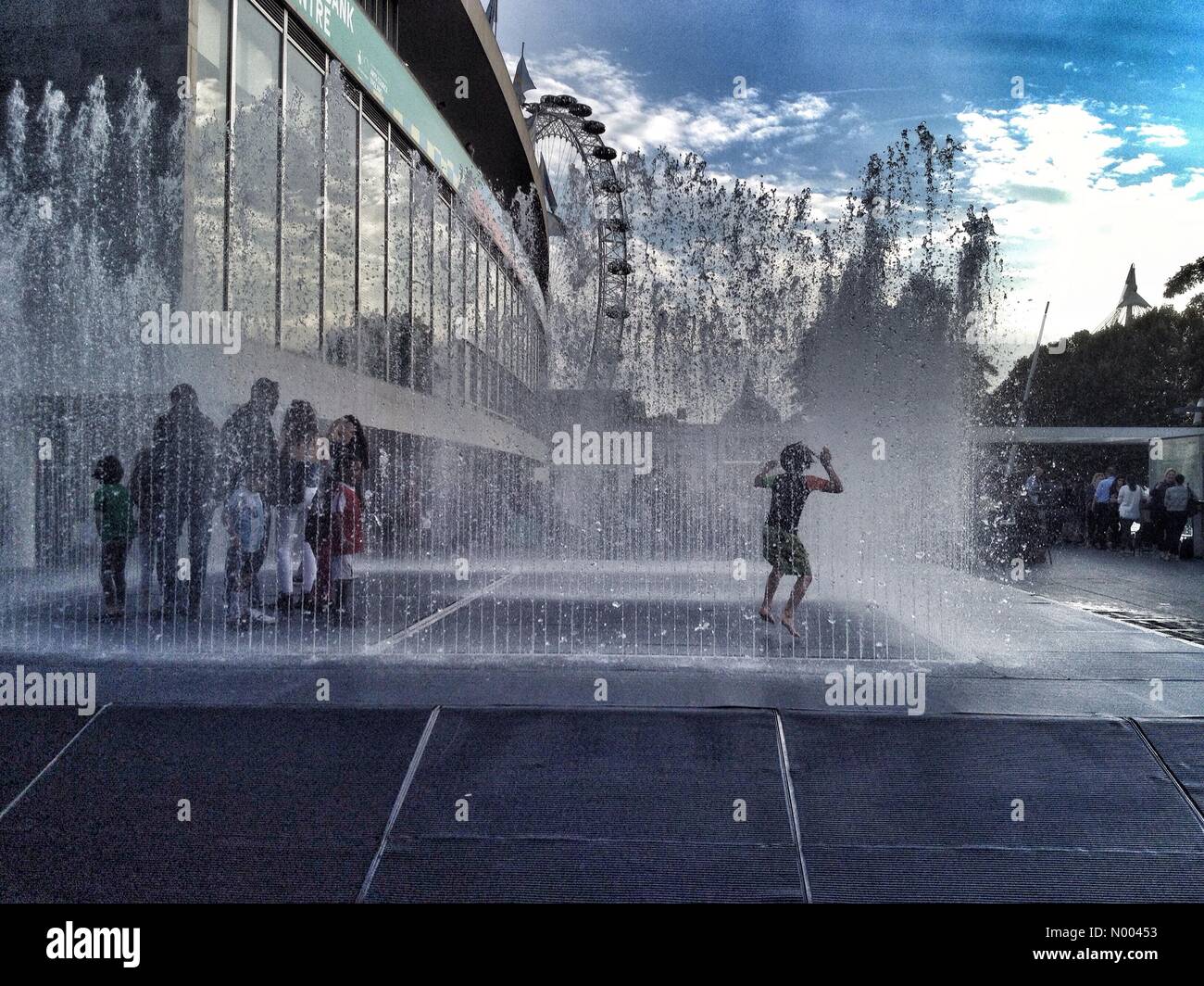 London, UK. 28th Aug, 2015. People frolic in the fountain outside the ...