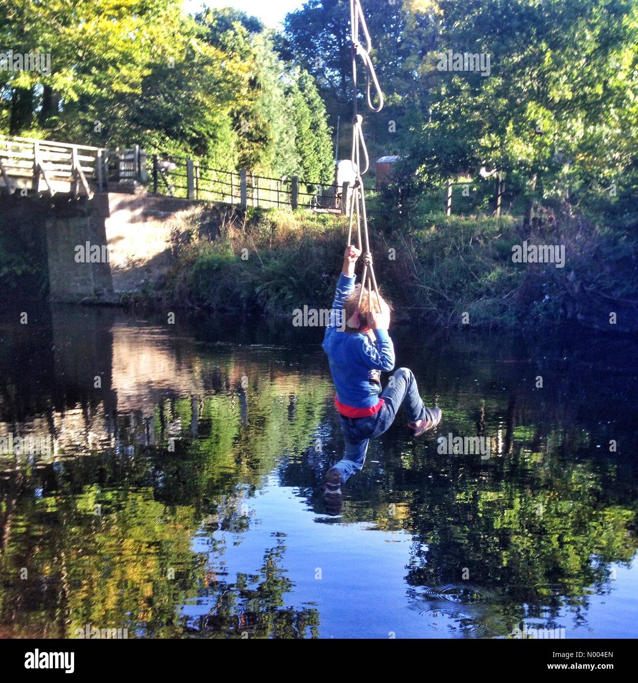 Child swinging rope river water hi-res stock photography and images - Alamy