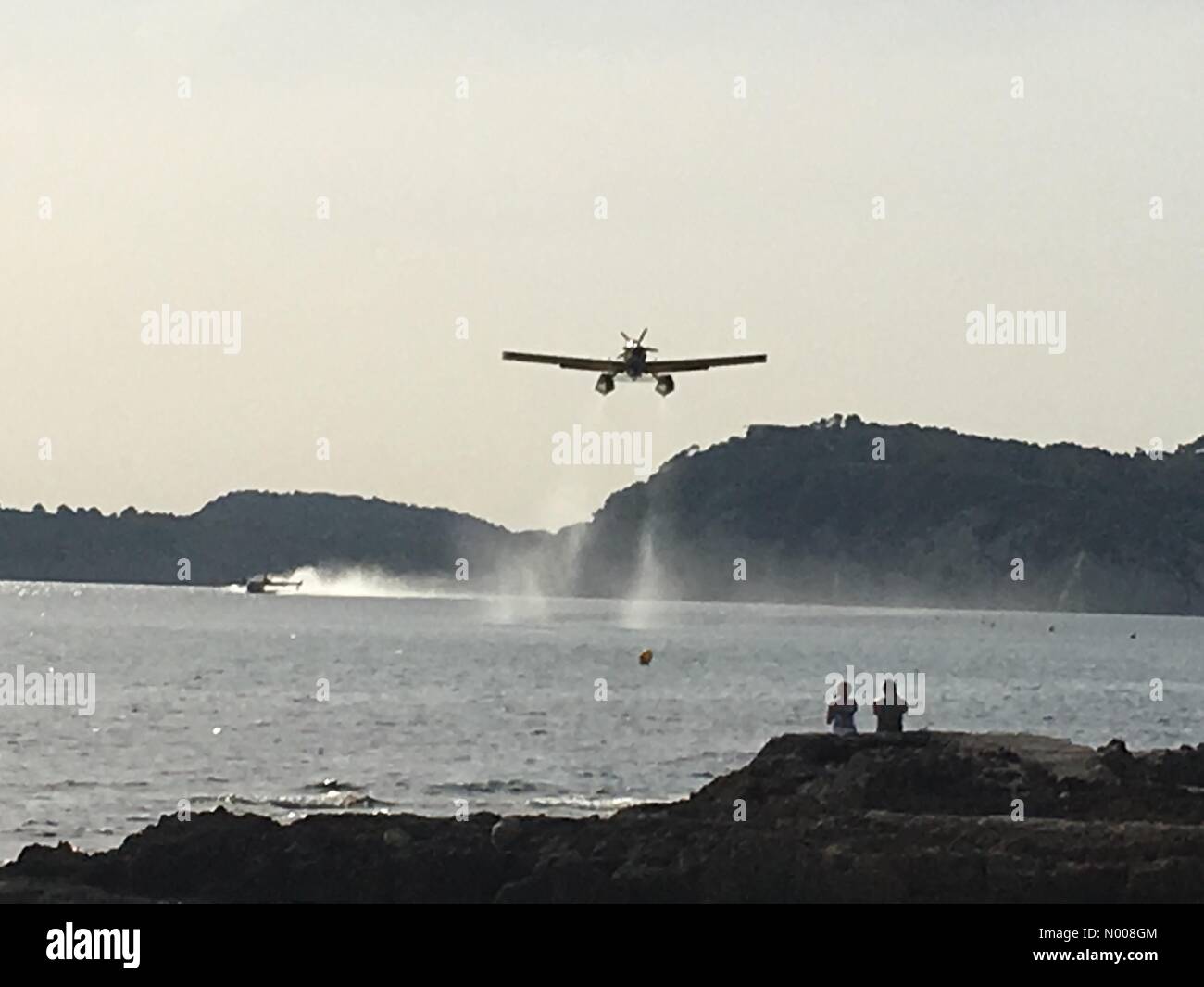 Amphibious plane and helicopter with water bucket, fighting the out of ...