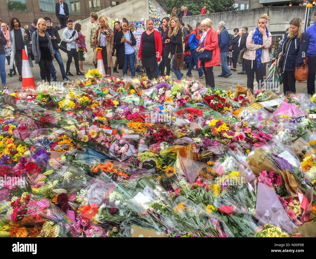 The public observe flowers and tributes left at London Bridge to those ...