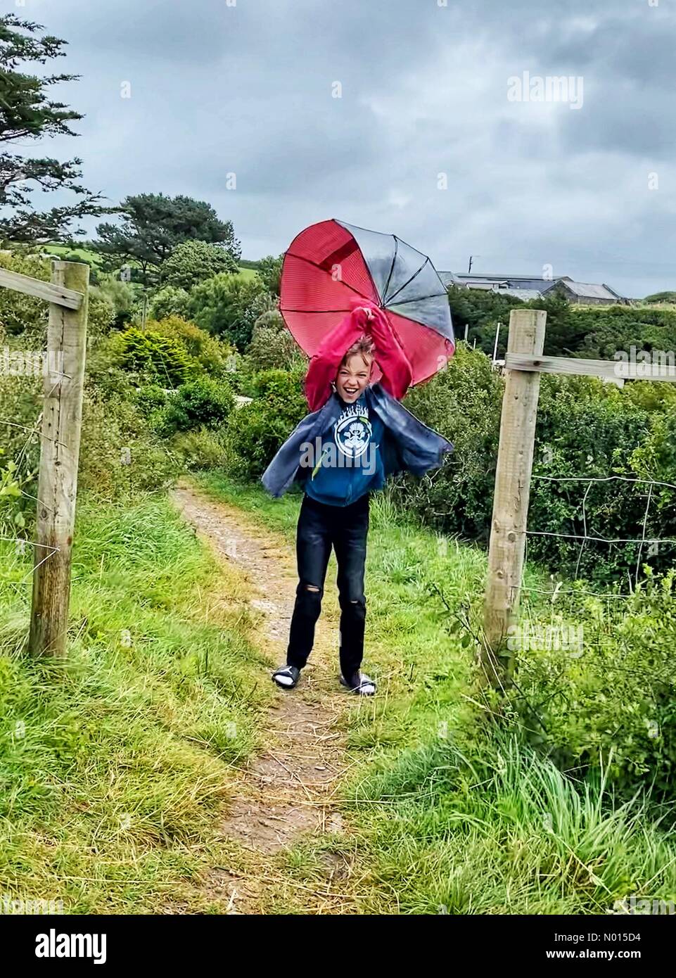 UK Weather: Jack Porter and his Umbrella battle winds during Storm ...