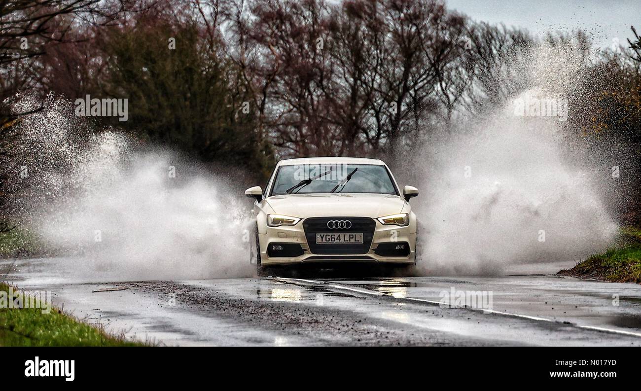 UK Weather: Vehicles speed through standing puddles creating big splash ...