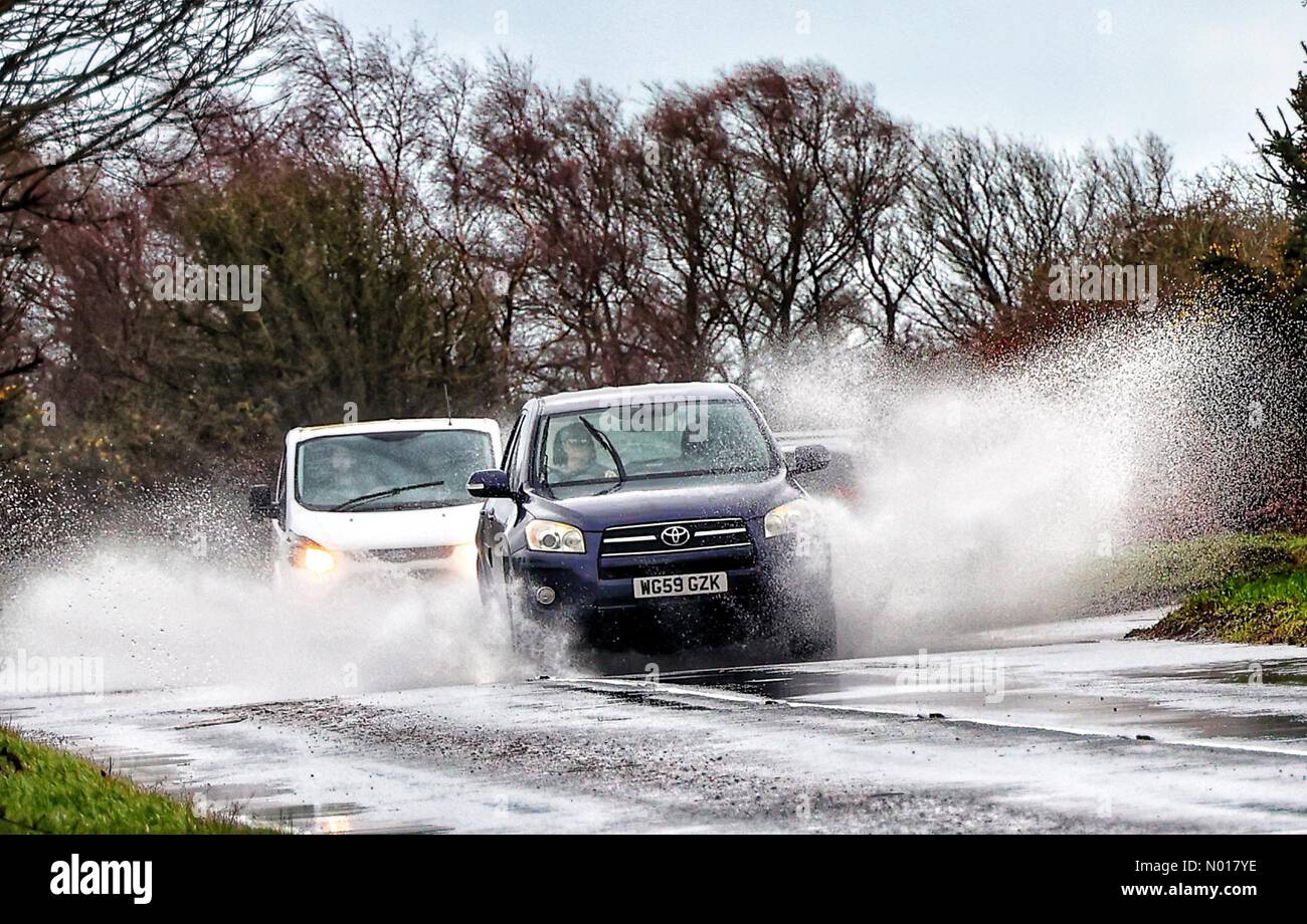 UK Weather: Vehicles speed through standing puddles creating big splash ...
