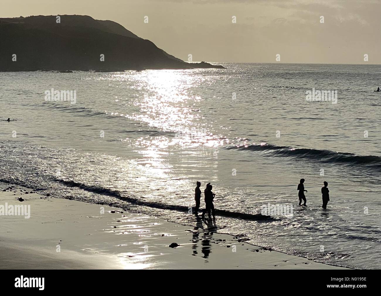 Swimmers walk into the sea at the start of a stunning autumn day at ...