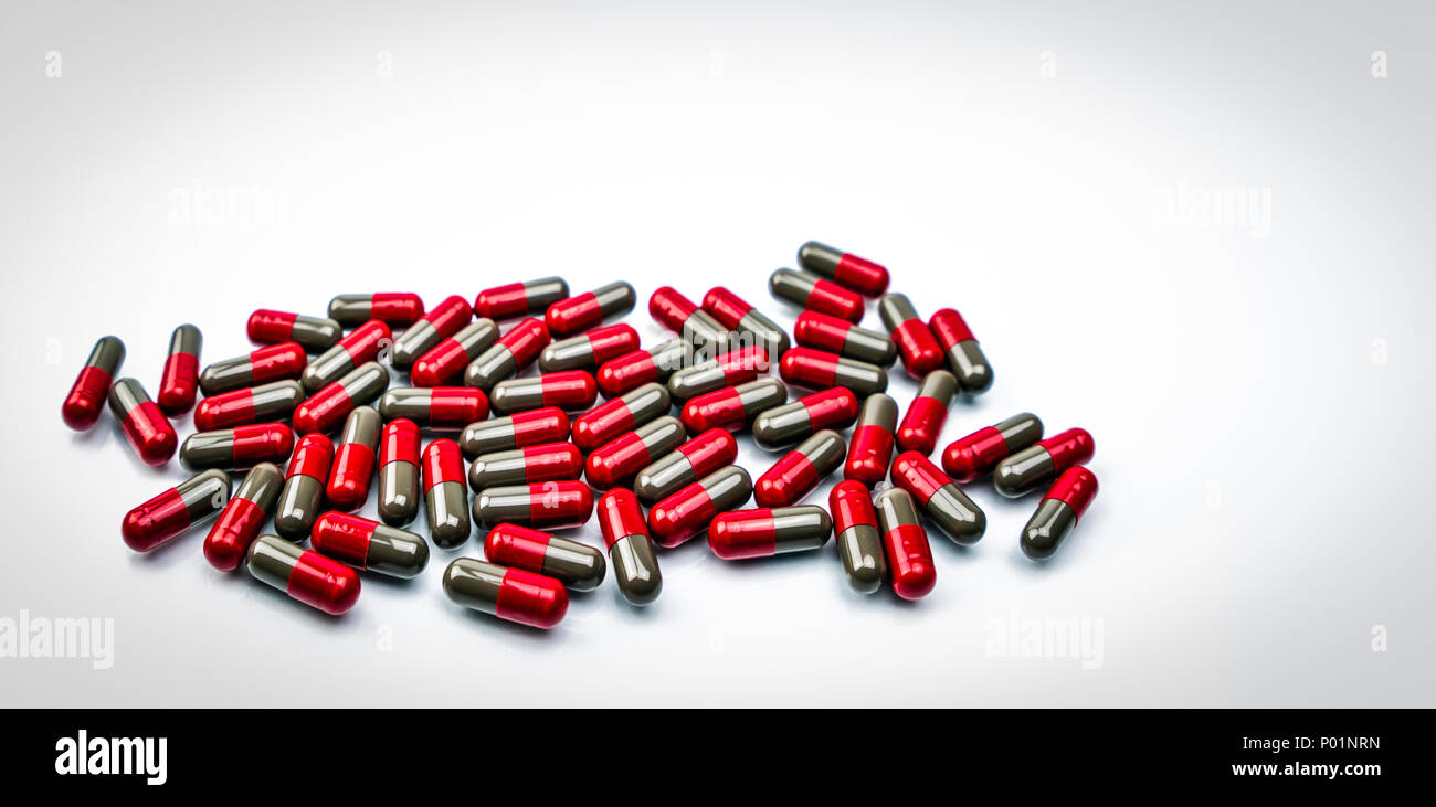 Pile of red and grey capsule pills isolated on white background with ...