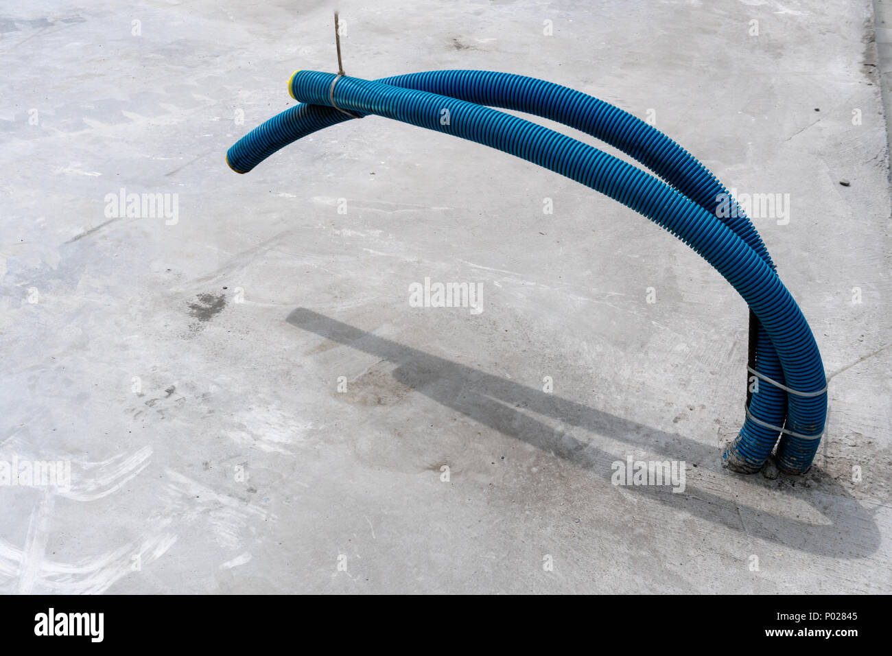 blue plastic tubes and piping for electrical wiring and concrete floor ...