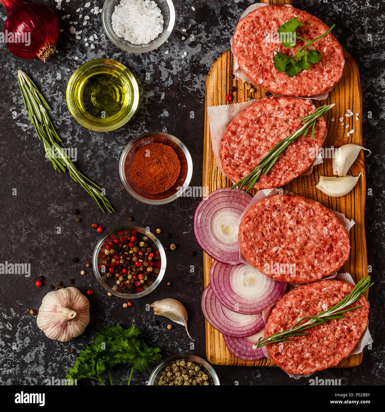Raw ground beef meat steak cutlets with herbs and spices on dsrk ...