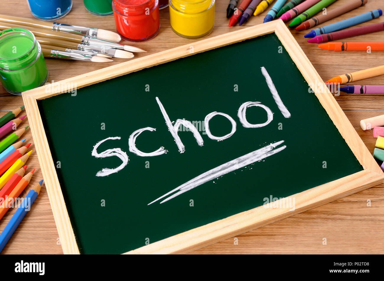 The word School written on a small elementary blackboard with various ...