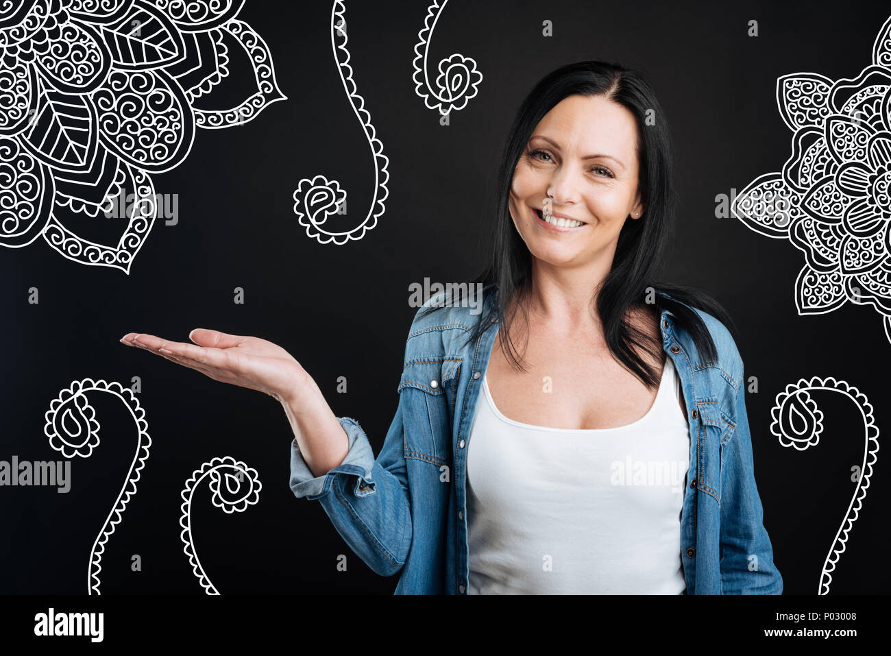 Cheerful artist smiling and showing her new painting Stock Photo - Alamy
