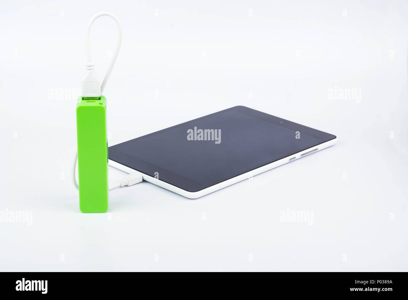 White tablet charge through battery power bank Stock Photo - Alamy