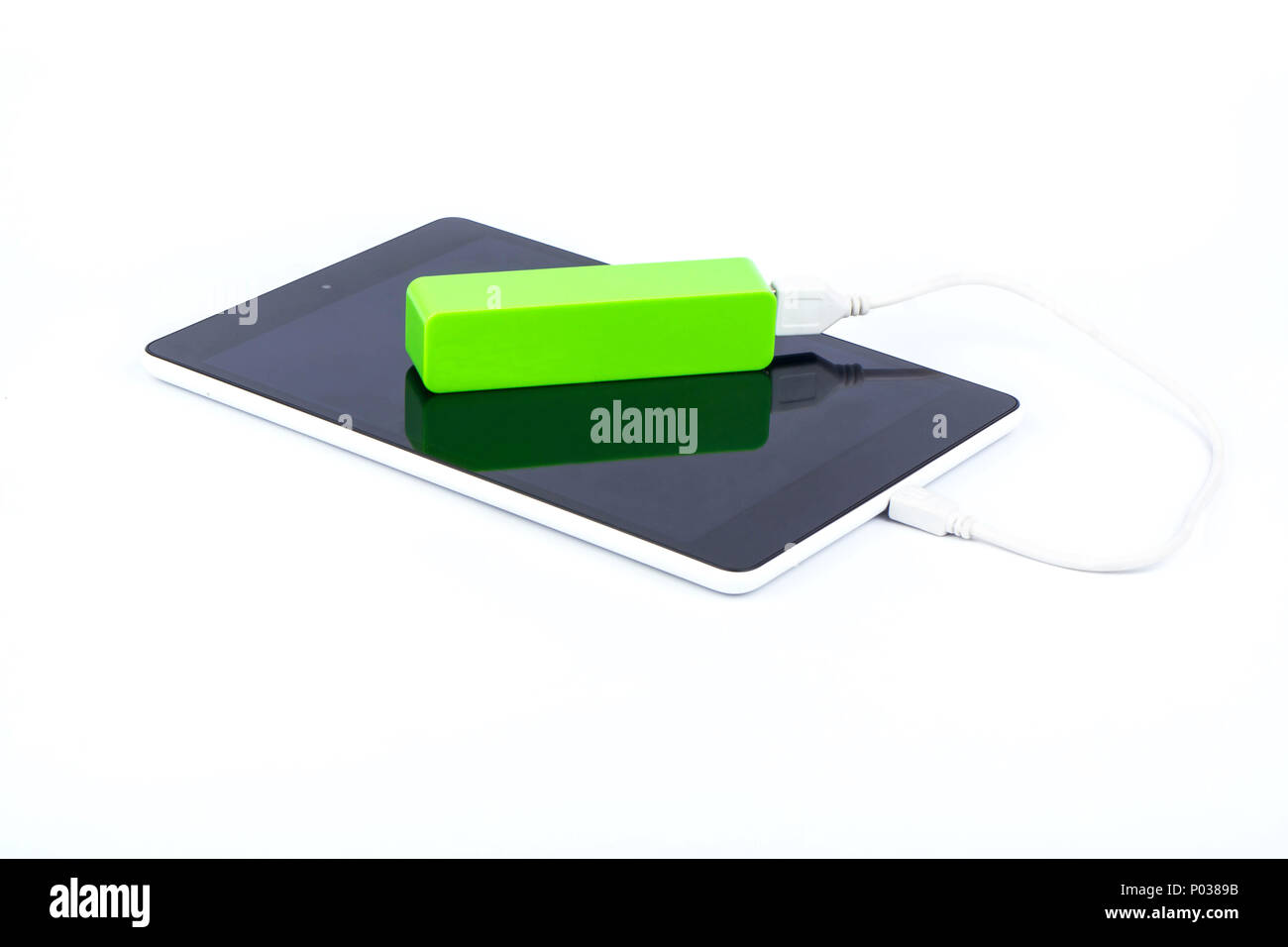 White tablet charge through battery power bank Stock Photo - Alamy