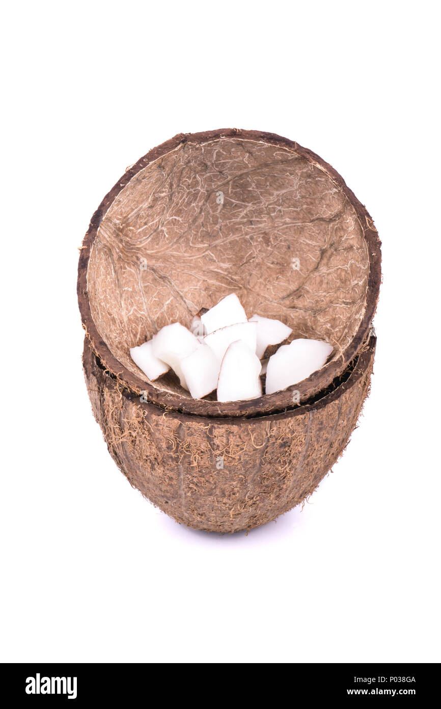 Two halves of a coconut shell with sliced fruit slices on a white ...
