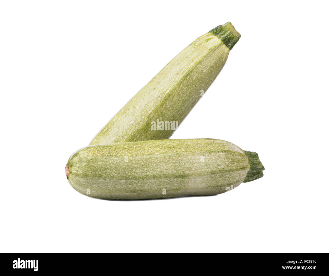 Two green vegetable marrow one of which stand on a white background ...