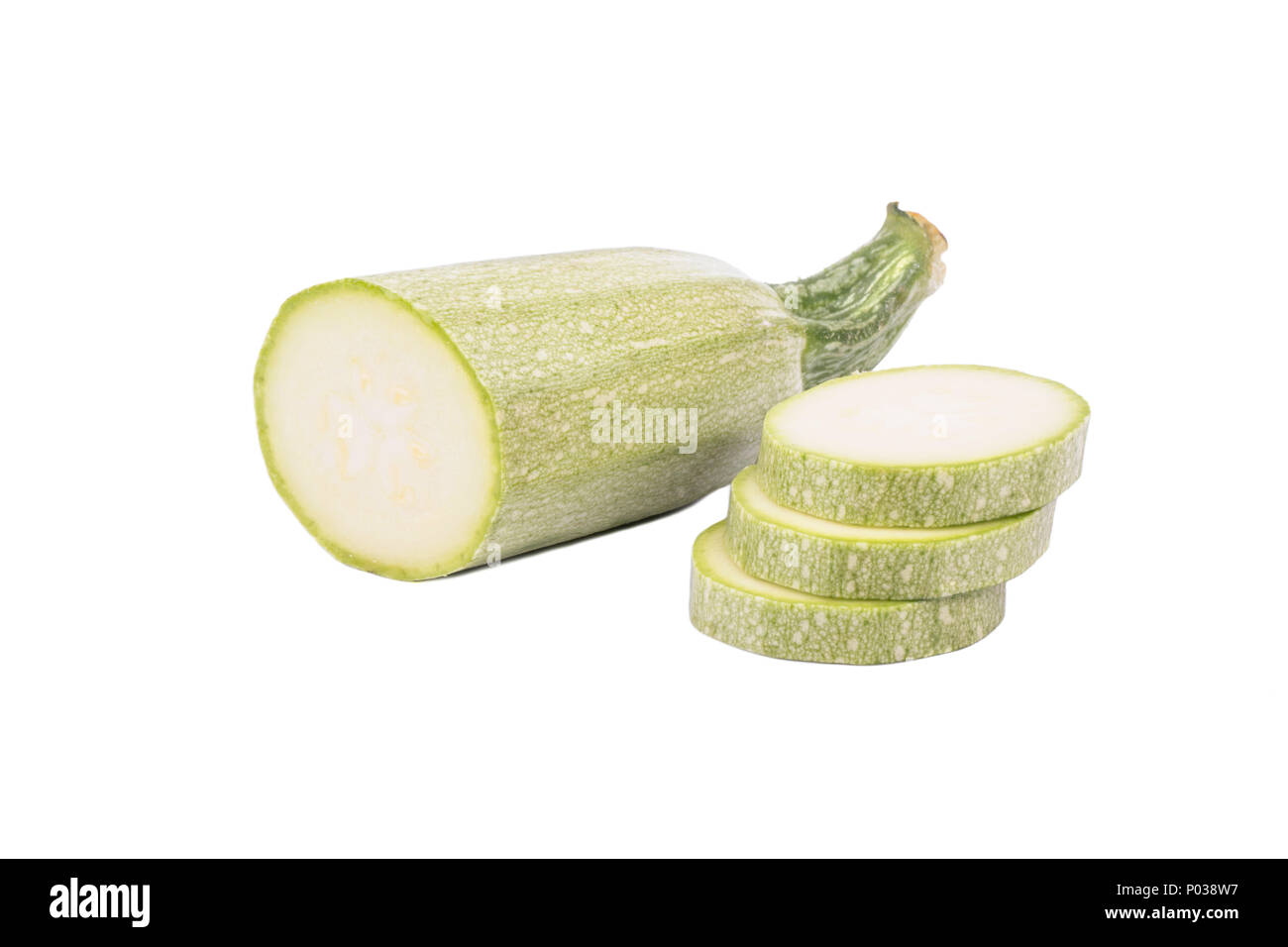 Half of green vegetable marrow with three slices on a white background ...