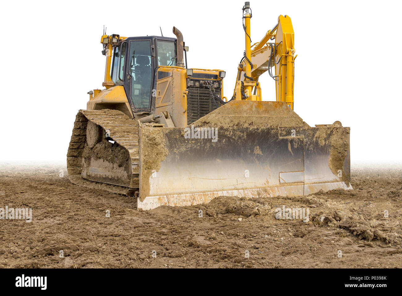 yellow bulldozer at a loamy construction site, partly isolated in white ...