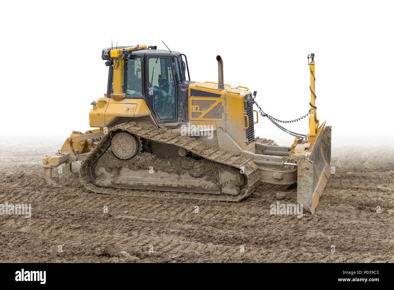 yellow bulldozer at a loamy construction site, partly isolated in white ...