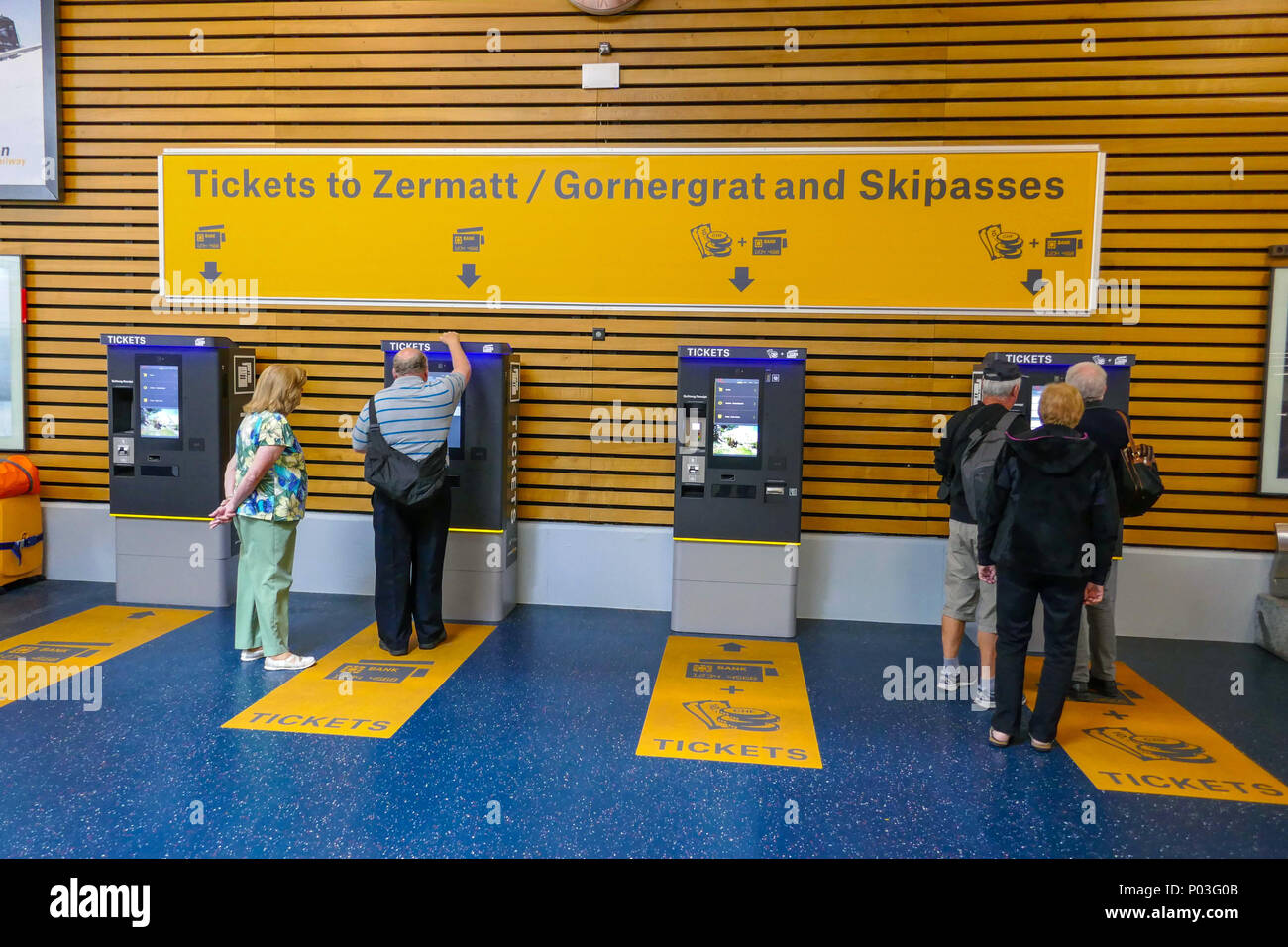 People at ticket machines, Matterhorn terminal in Täsch Switzerland ...