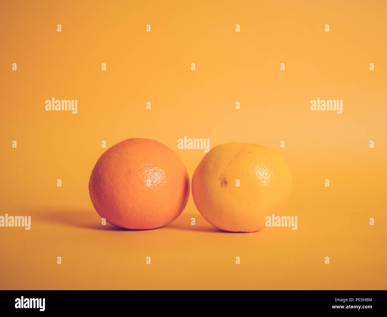 A red and yellow grapefruit on orange background Stock Photo - Alamy