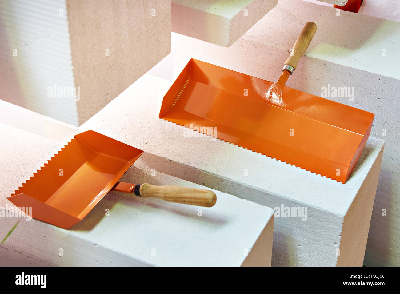 Orange building tools and foam concrete blocks Stock Photo - Alamy