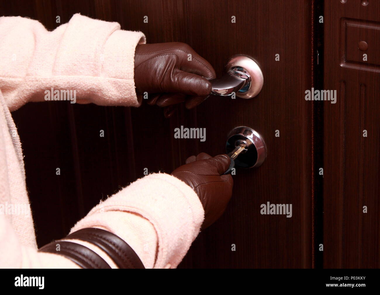 Women's hands in brown gloves open the lock on the door Stock Photo - Alamy