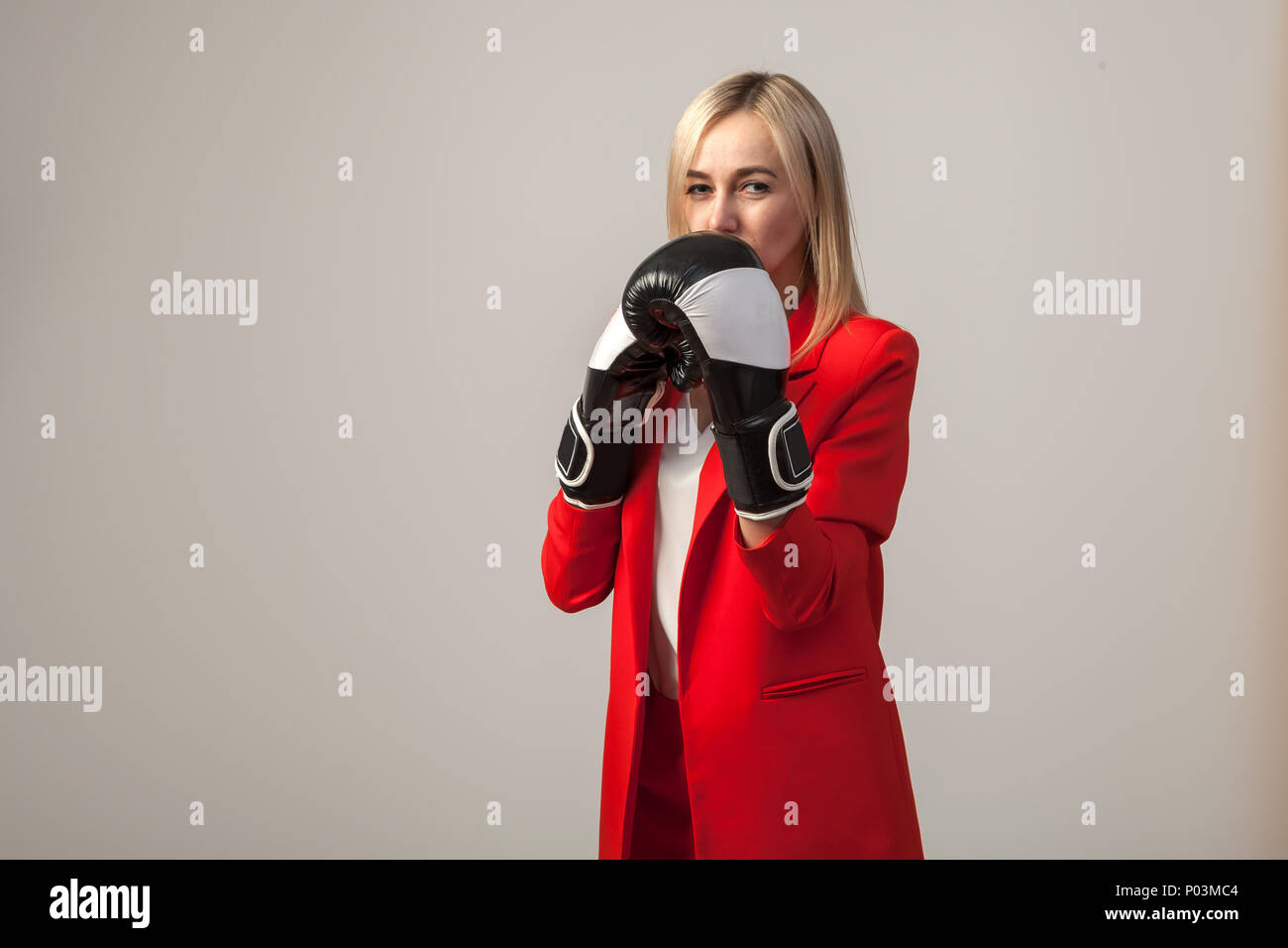 Young beautiful white blond girl in a bright red strict suit with a ...