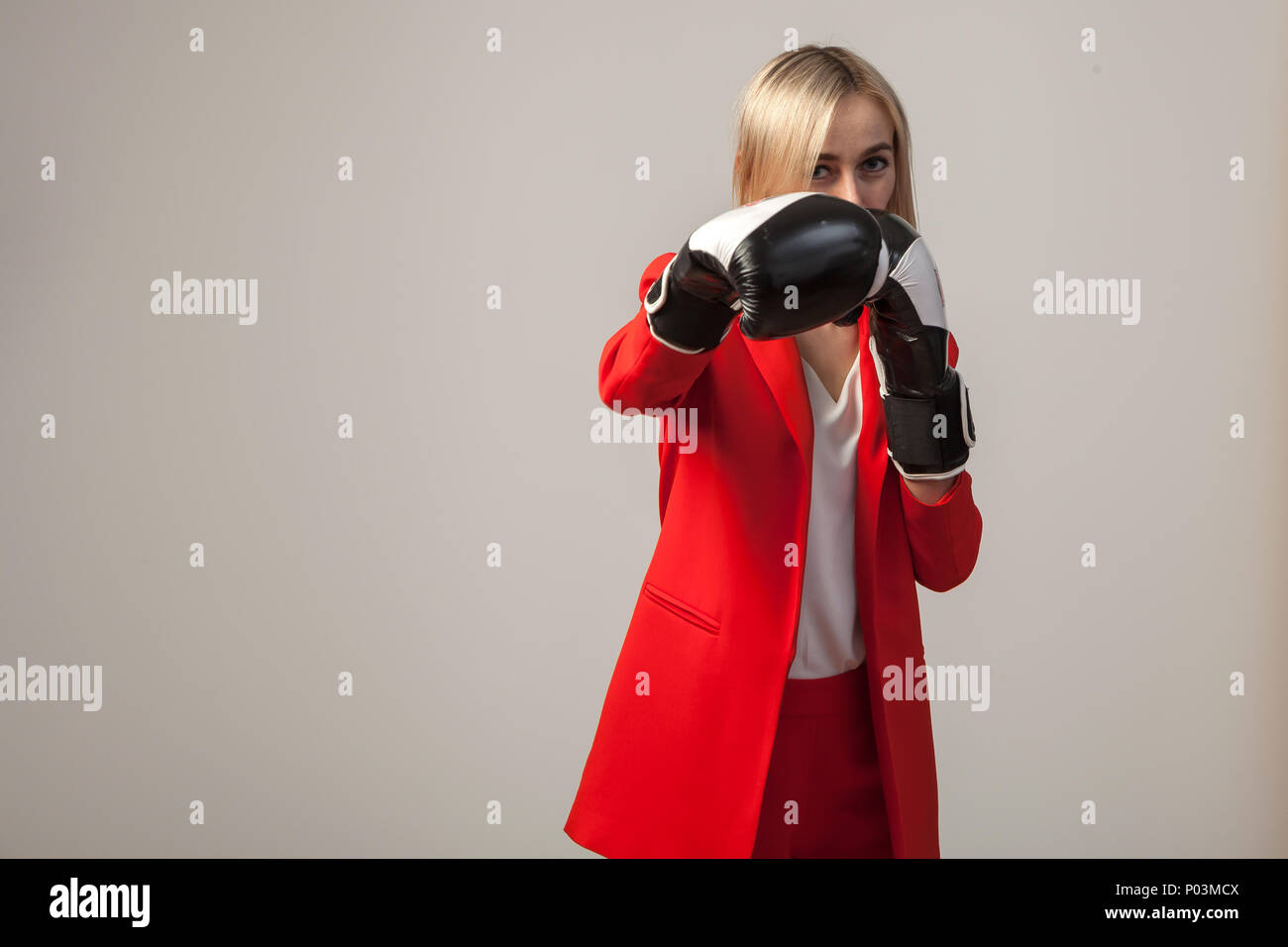 Young beautiful white blond girl in a bright red strict suit with a ...