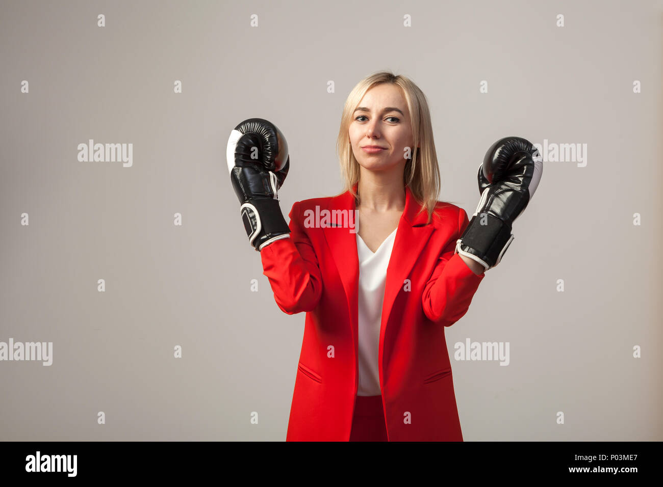 Young beautiful white blond girl in a bright red strict suit with a ...
