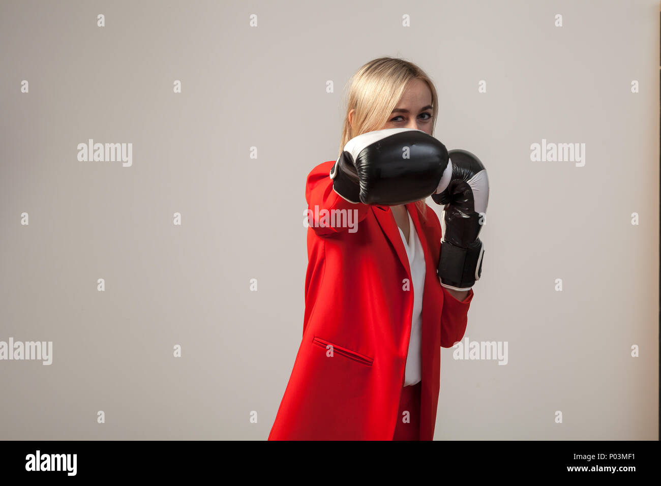 Young beautiful white blond girl in a bright red strict suit with a ...