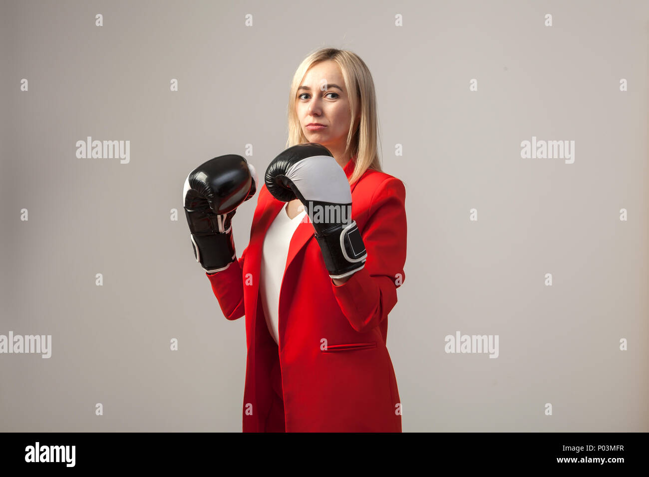 Young beautiful white blond girl in a bright red strict suit with a ...