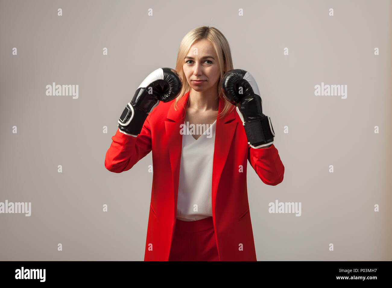 Young beautiful white blond girl in a bright red strict suit with a ...