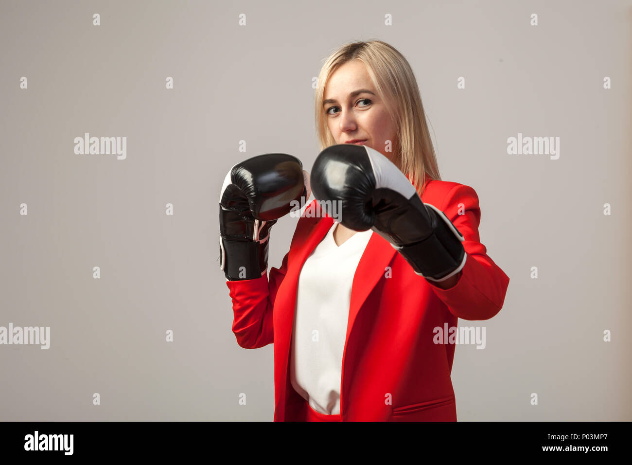 Young beautiful white blond women in a bright red strict suit with a ...