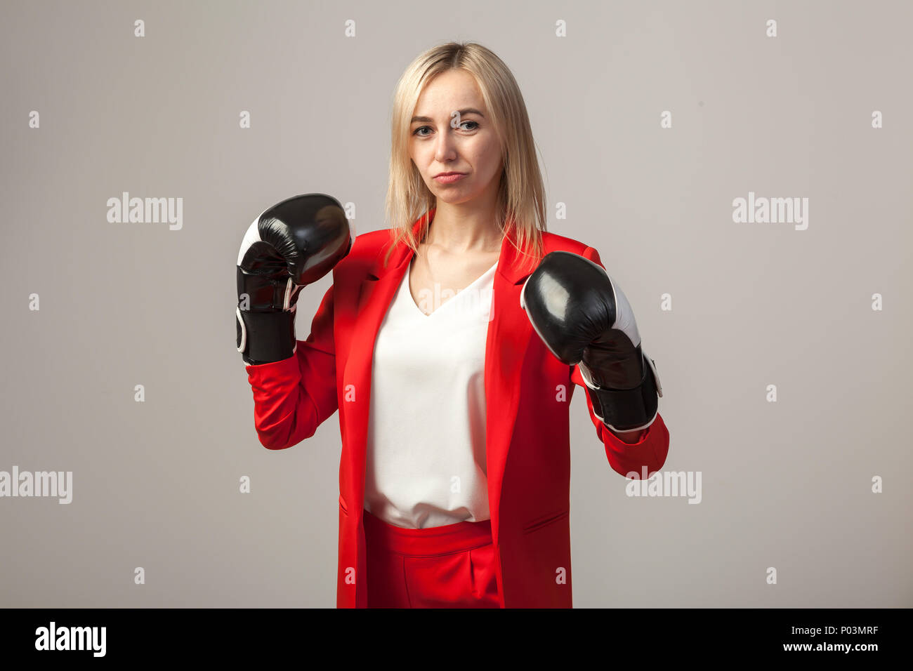 Young beautiful white blond women in a bright red strict suit with a ...