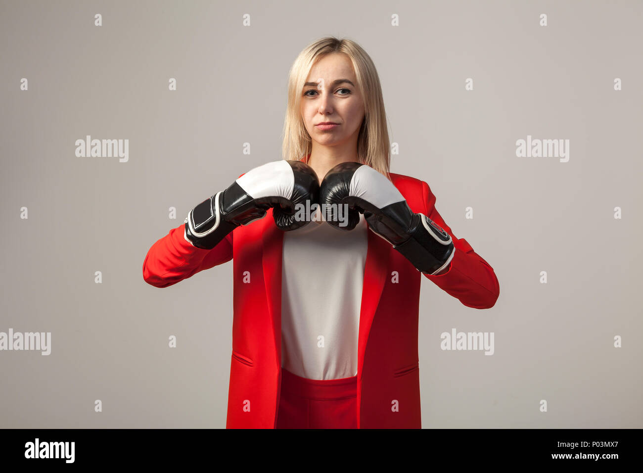 Young beautiful white blond women in a bright red strict suit with a ...