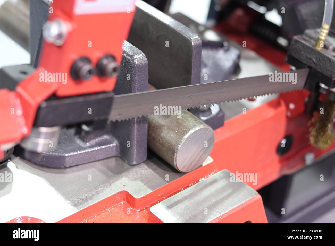 Steel bar cutting by band saw machine with coolant Stock Photo - Alamy