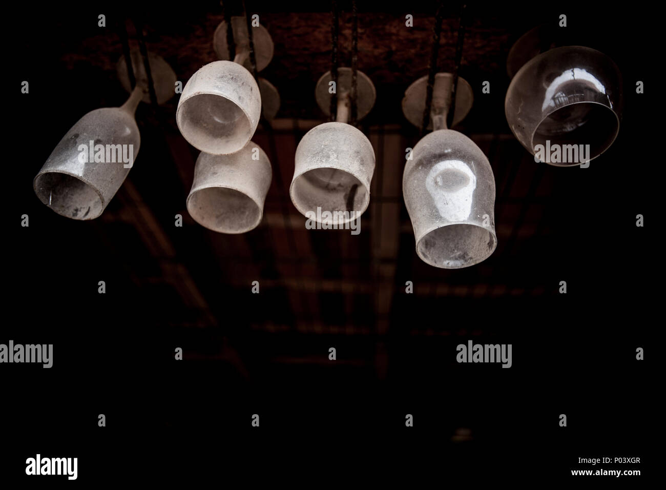 Dusty bar glasses hung upside down Stock Photo - Alamy