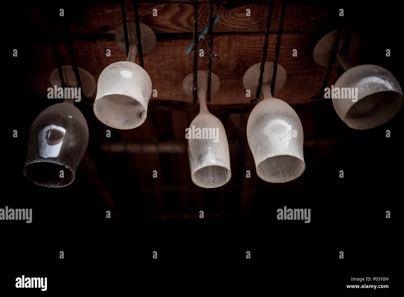 Dusty bar glasses hung upside down Stock Photo - Alamy