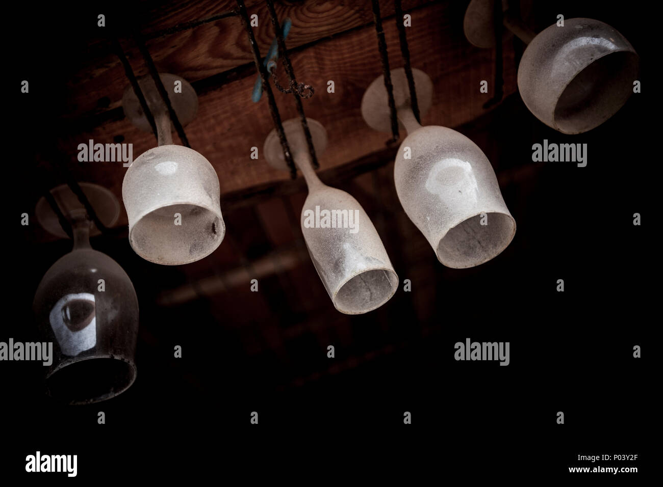 Dusty bar glasses hung upside down Stock Photo - Alamy