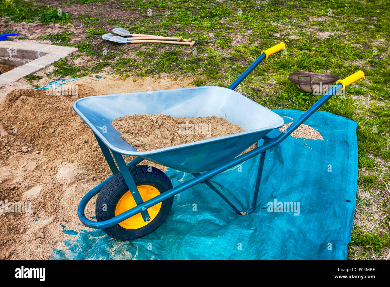 Blue and yellow wheelbarrow for transporting sand or heavy materials ...