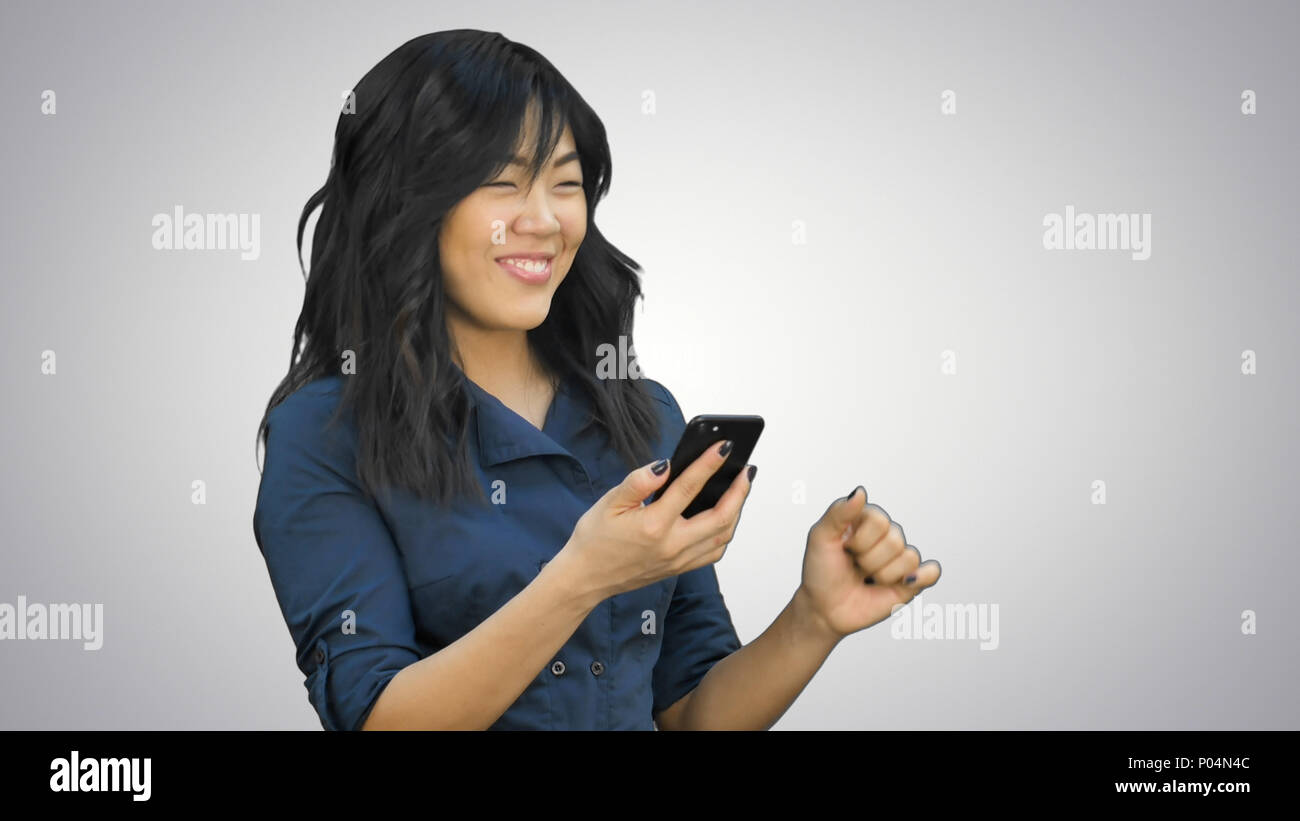 Positive young beautiful asian woman using mobile phone, dancing and ...