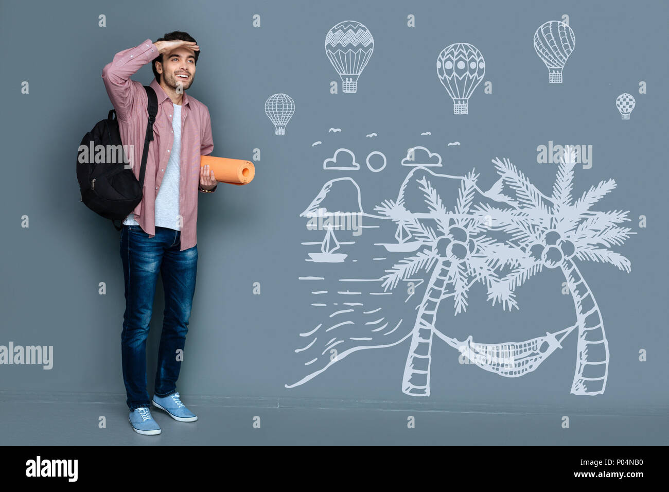Positive smiling man coming to the seaside while travelling Stock Photo ...